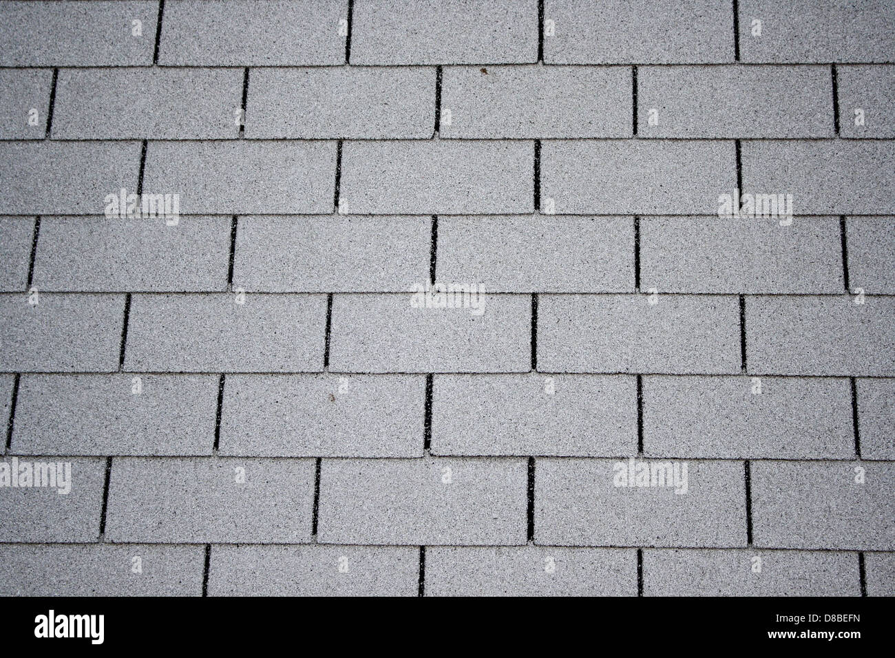 A close-up of gray roof shingles, highlighting the texture and pattern ...