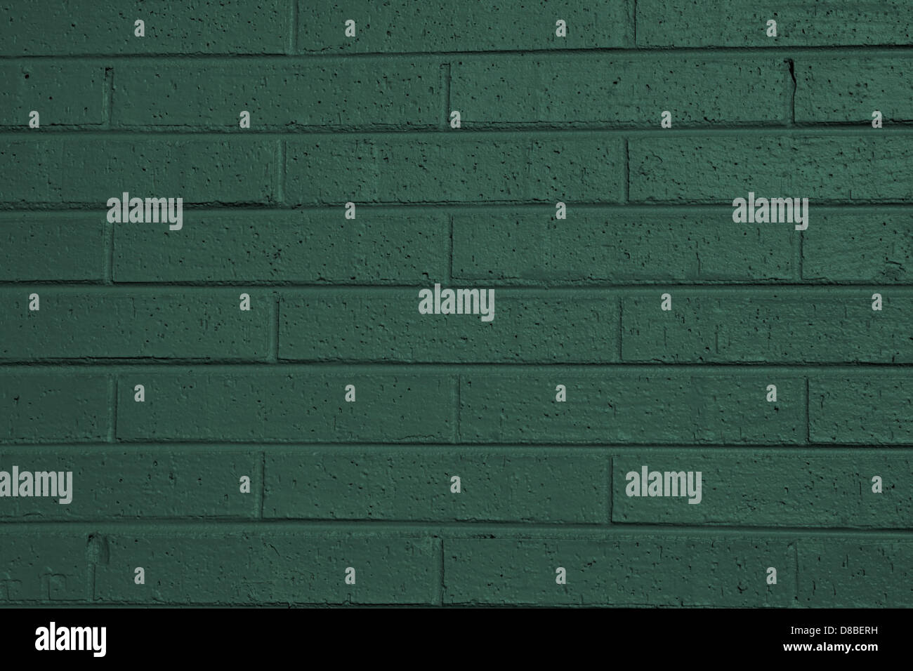 A close-up of a green painted brick wall, showcasing the texture of the ...