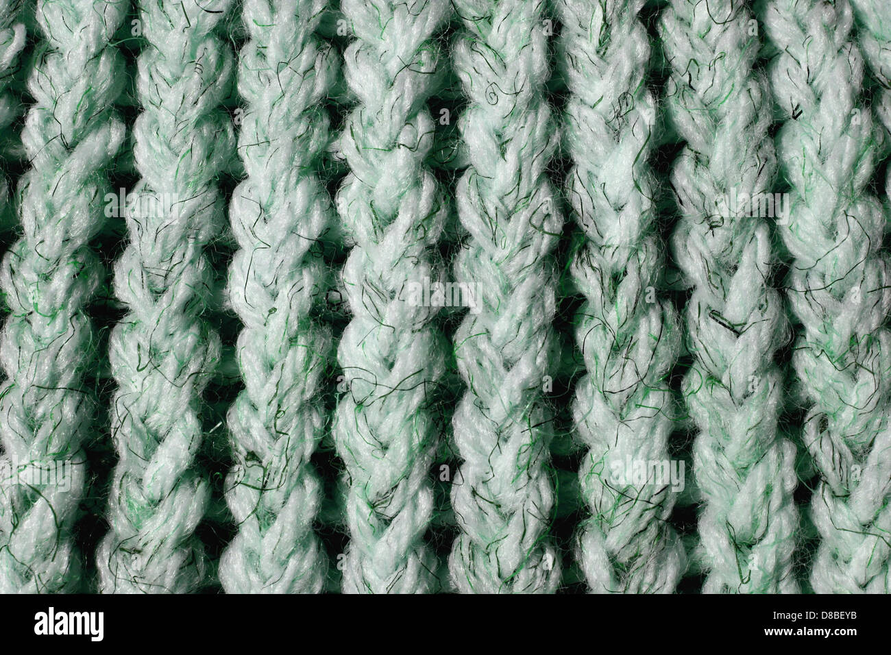 A close-up shot of a green and white knit fabric texture, displaying ...