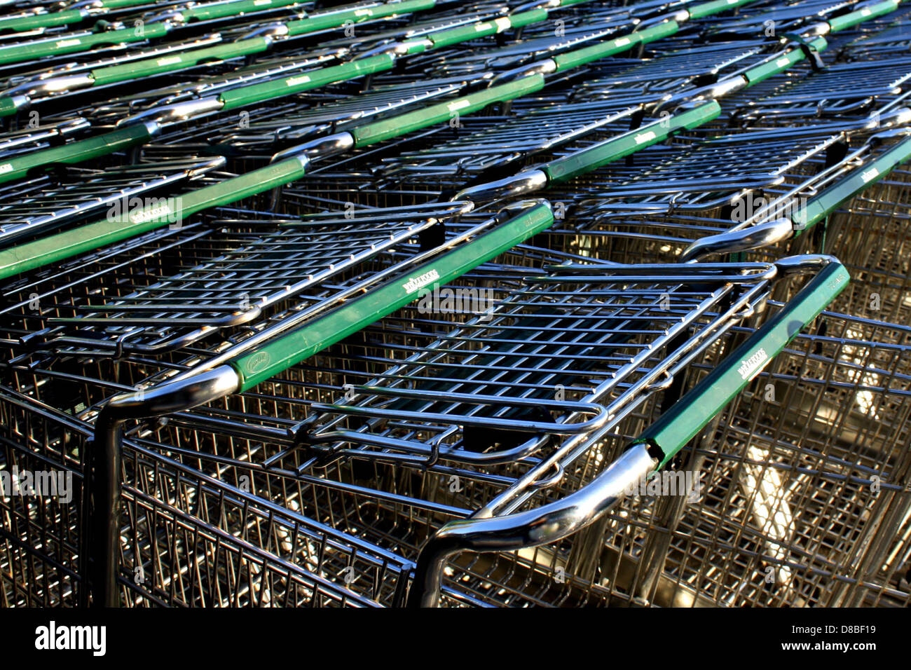 A collection of grocery carts lined up outside a supermarket. These ...