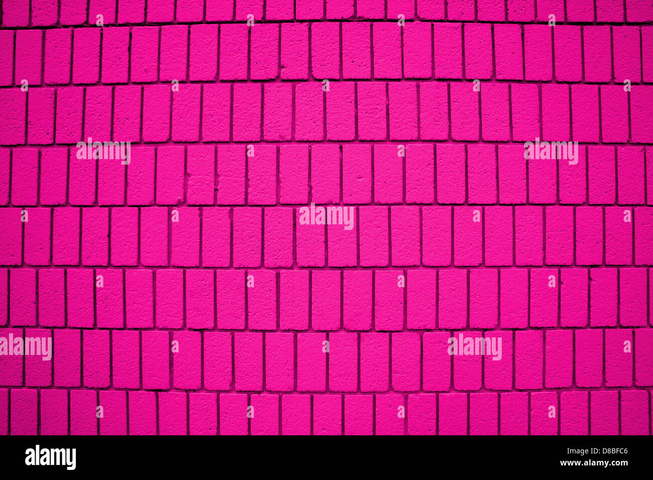A close-up of a hot pink brick wall with vertical brick orientation ...