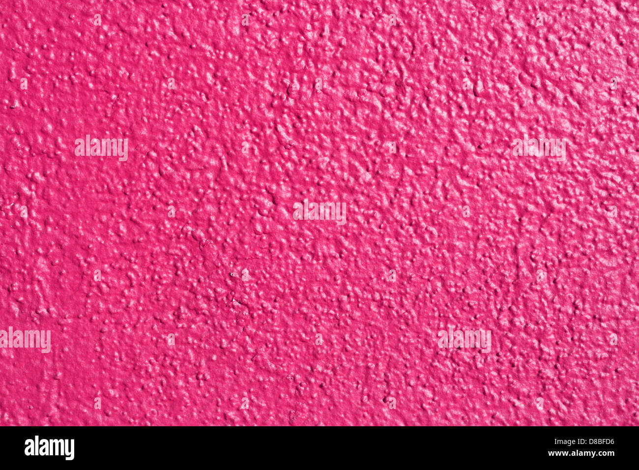 A close-up of a wall painted in a vibrant hot pink color, highlighting ...