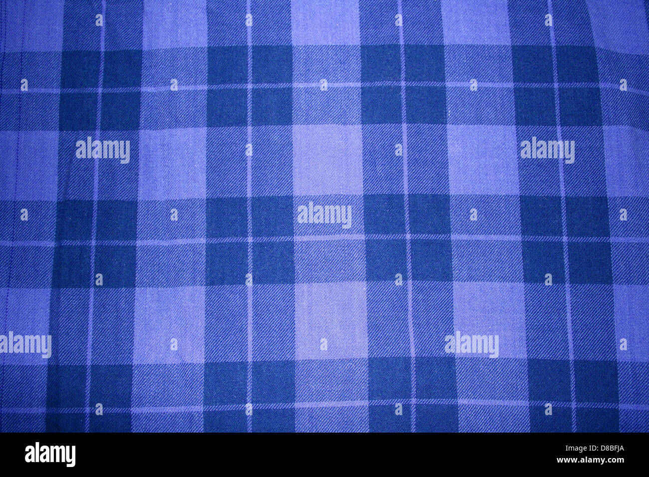 This stock photo features a close-up of indigo blue plaid fabric ...