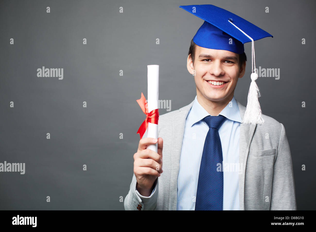 Portrait of confident student with graduation certificate looking at ...
