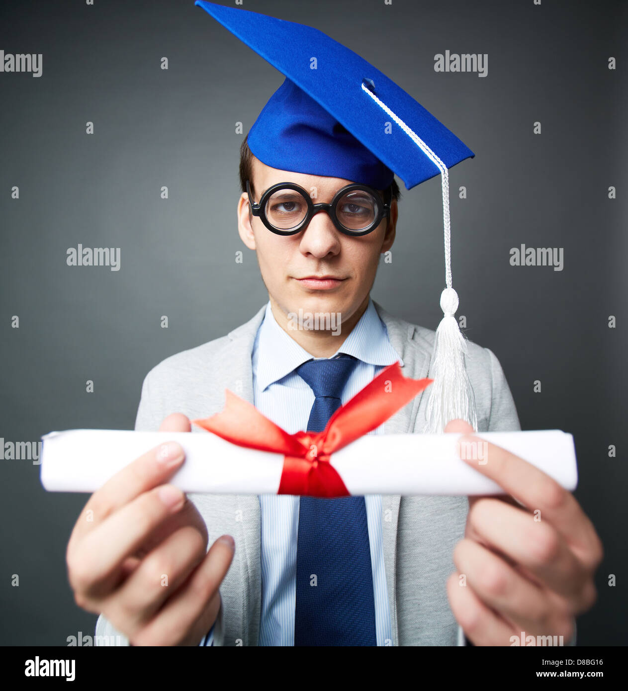 Portrait of confident student with graduation certificate looking at ...
