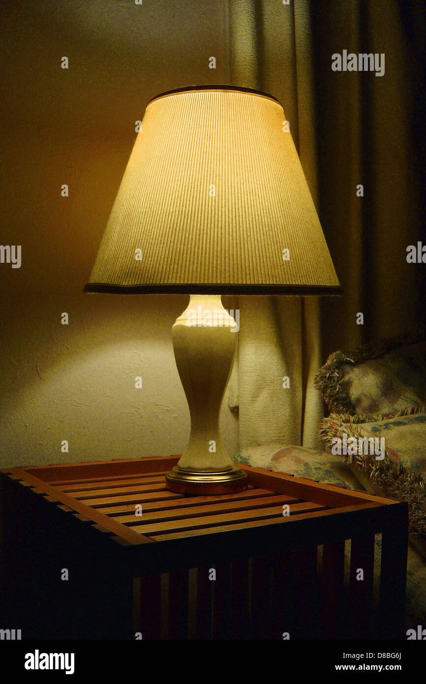 A lamp casting light in a dark room, providing a warm, inviting glow ...