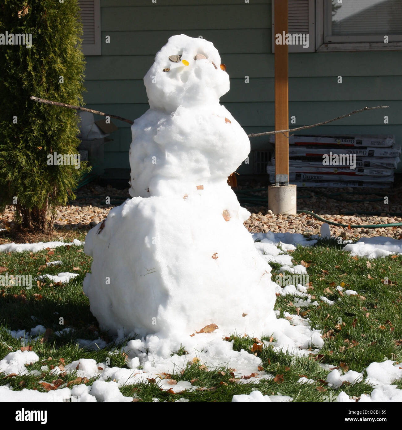 A snowman beginning to melt, as the warmth of the sun causes the snow ...