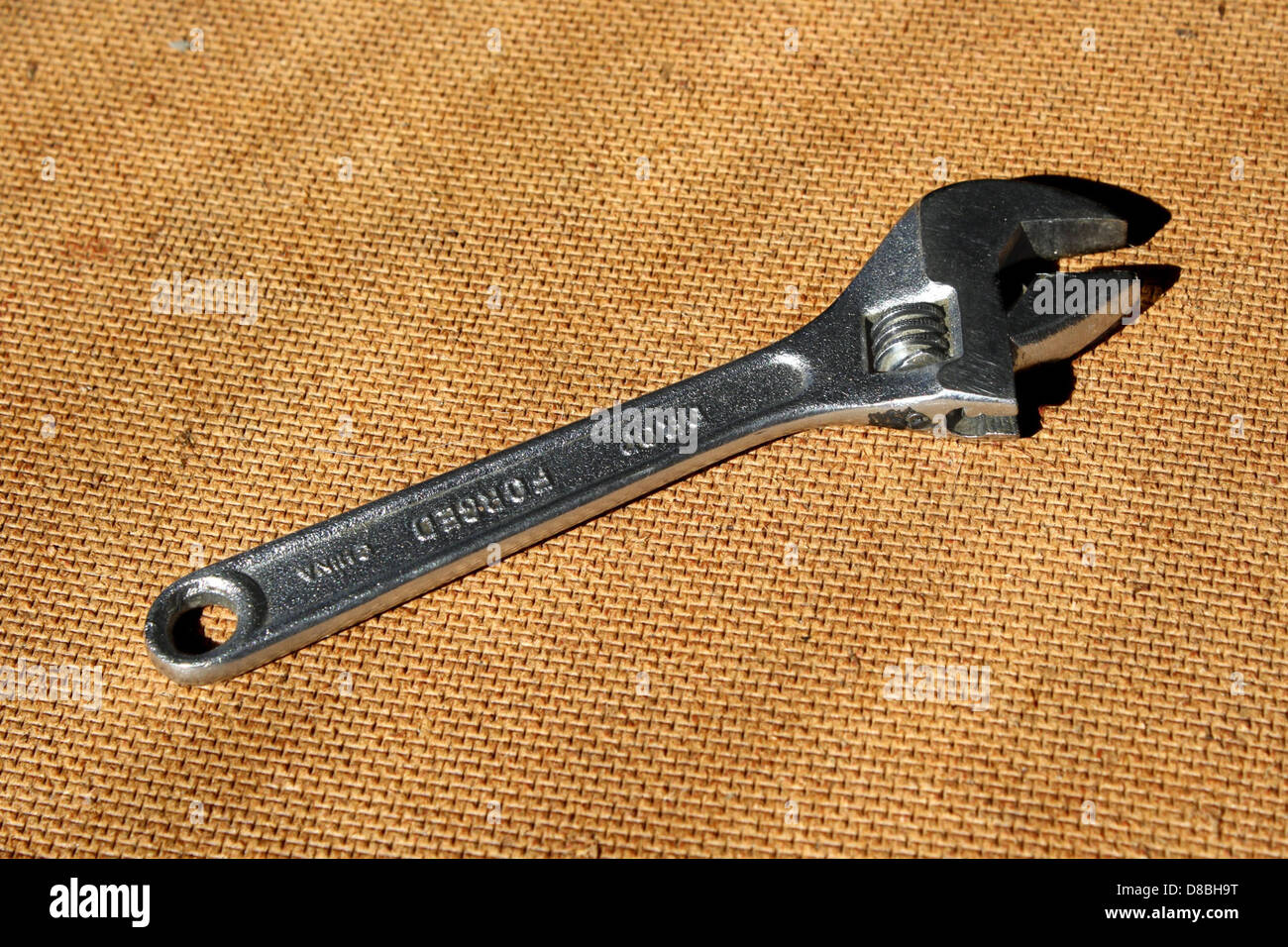 This image features a monkey wrench, also known as an adjustable ...