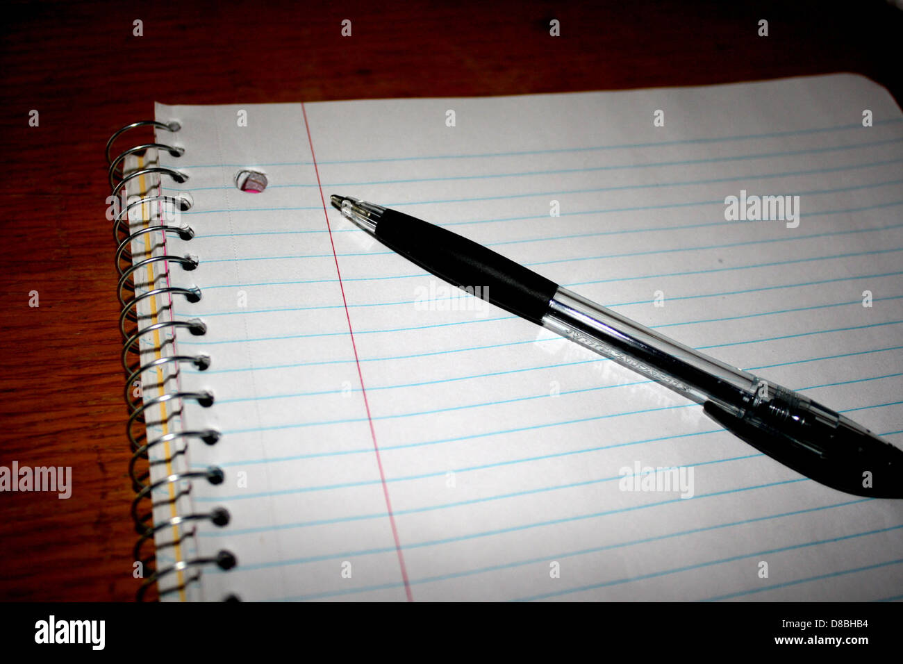 A close-up image of a notebook and pen on a surface, ready for writing ...