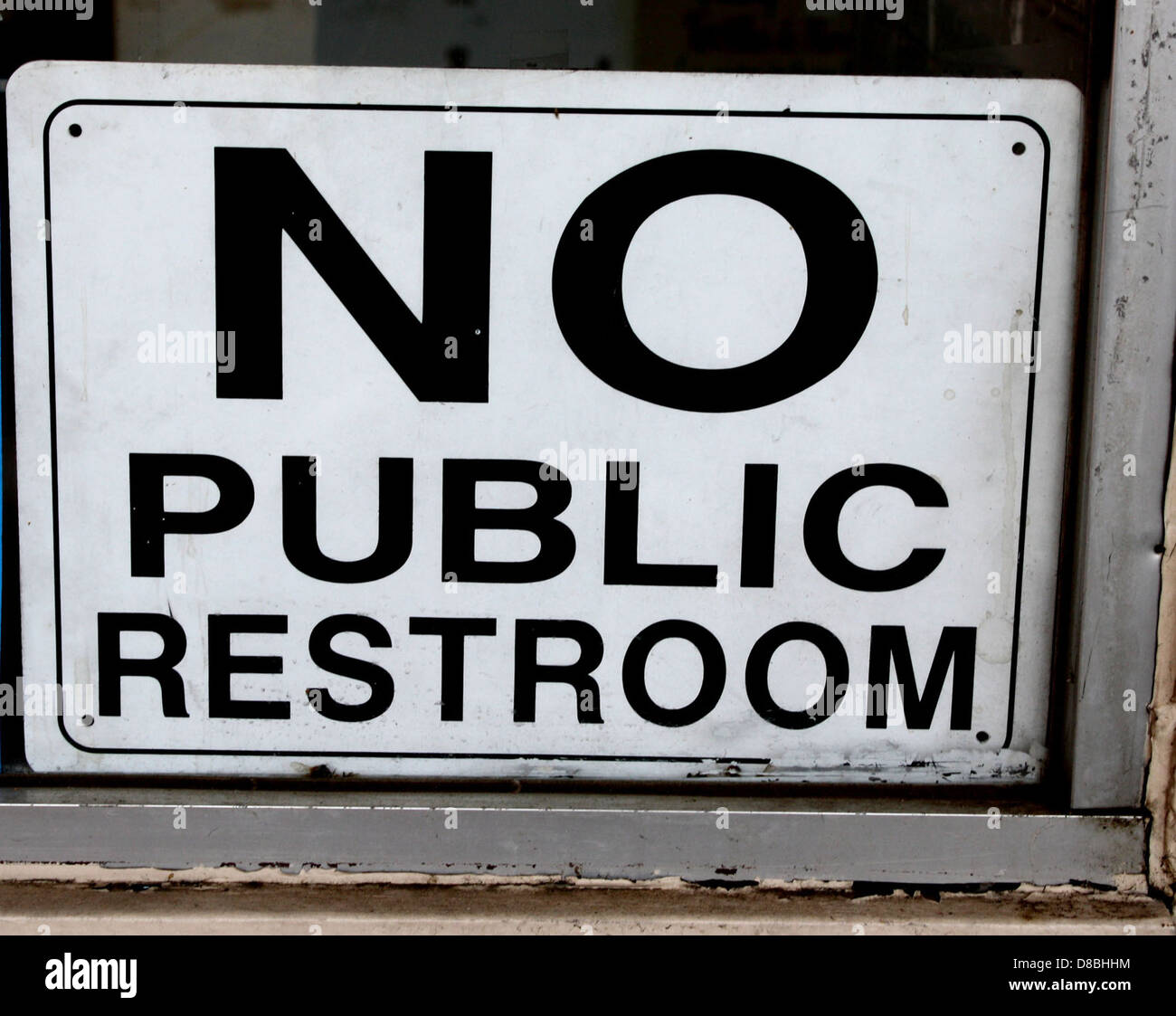 A sign indicating the absence of a public restroom, often placed in ...
