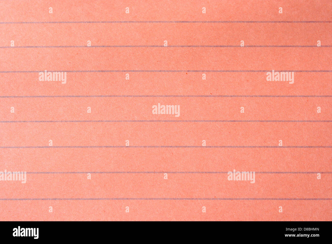 This close-up image shows the texture of orange notebook paper ...