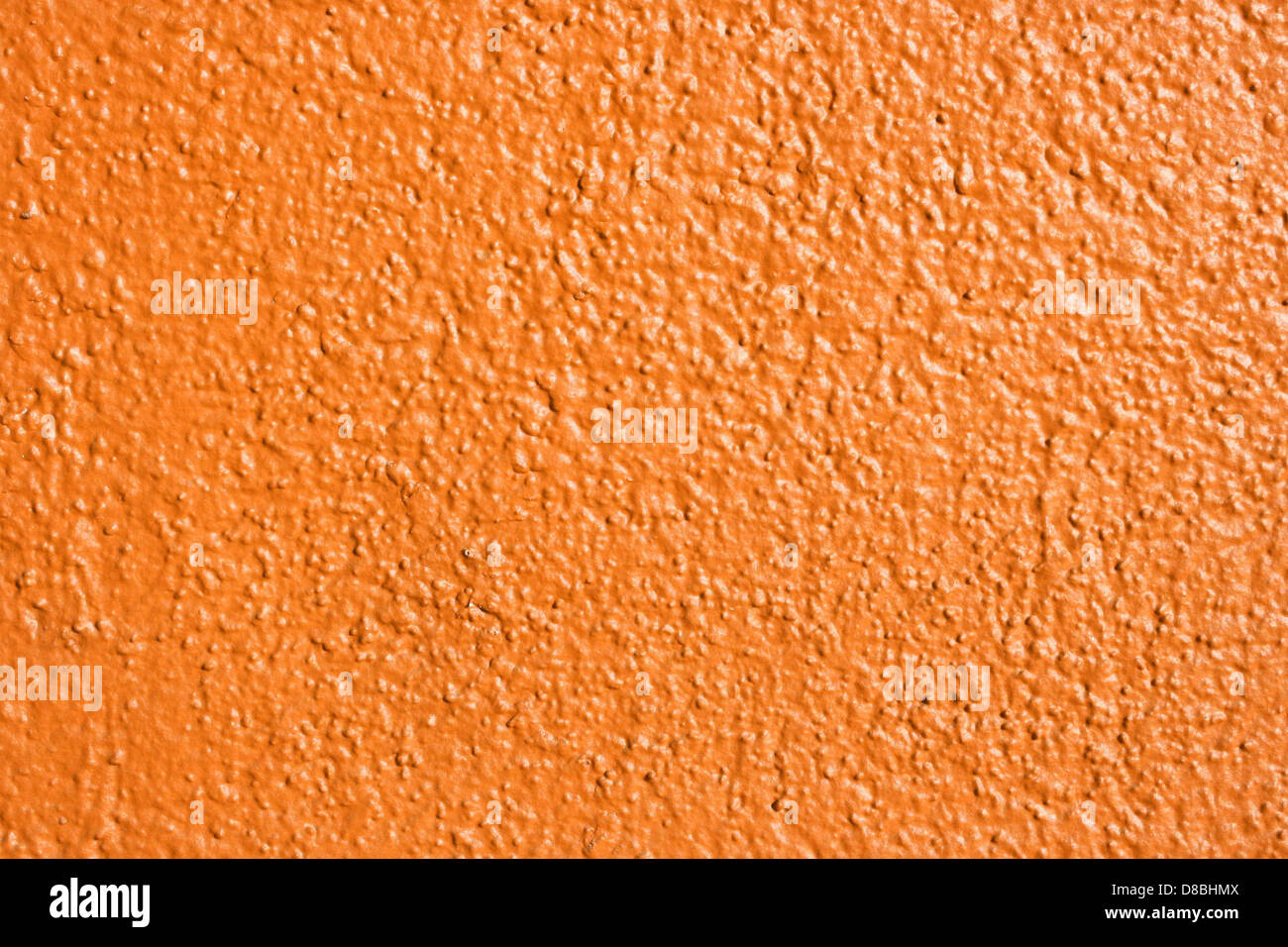 A close-up of a wall painted in orange, showing the smooth, matte ...