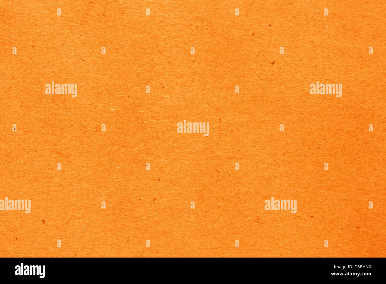 A close-up image of orange-colored paper with small flecks visible ...
