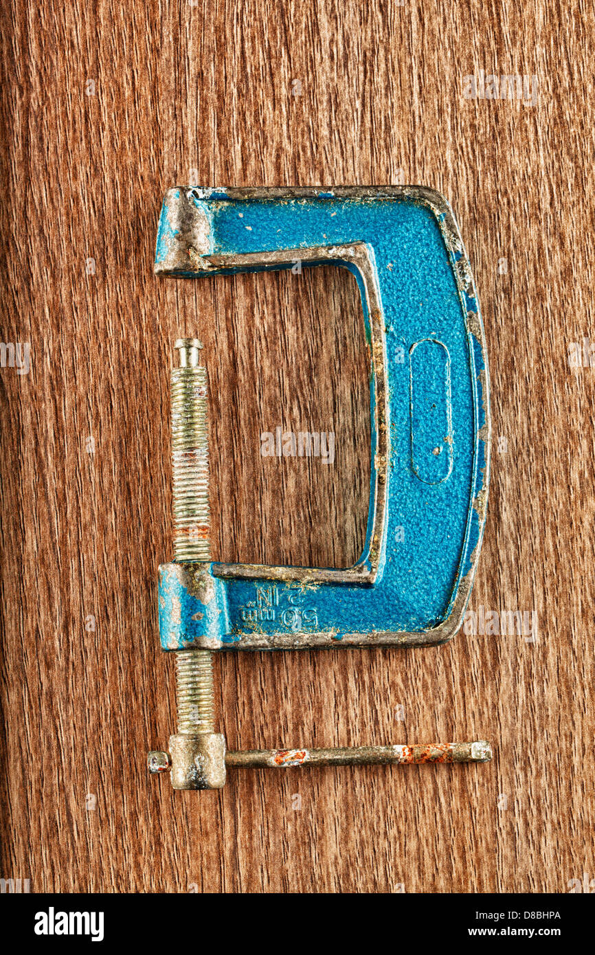 An old and rusty clamp over wooden background Stock Photo - Alamy