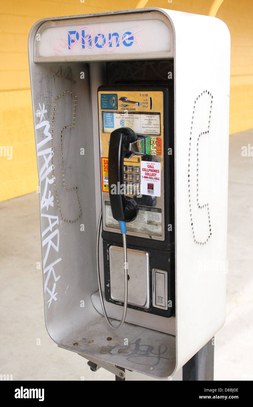 A pay phone booth covered in colorful graffiti is depicted in this ...
