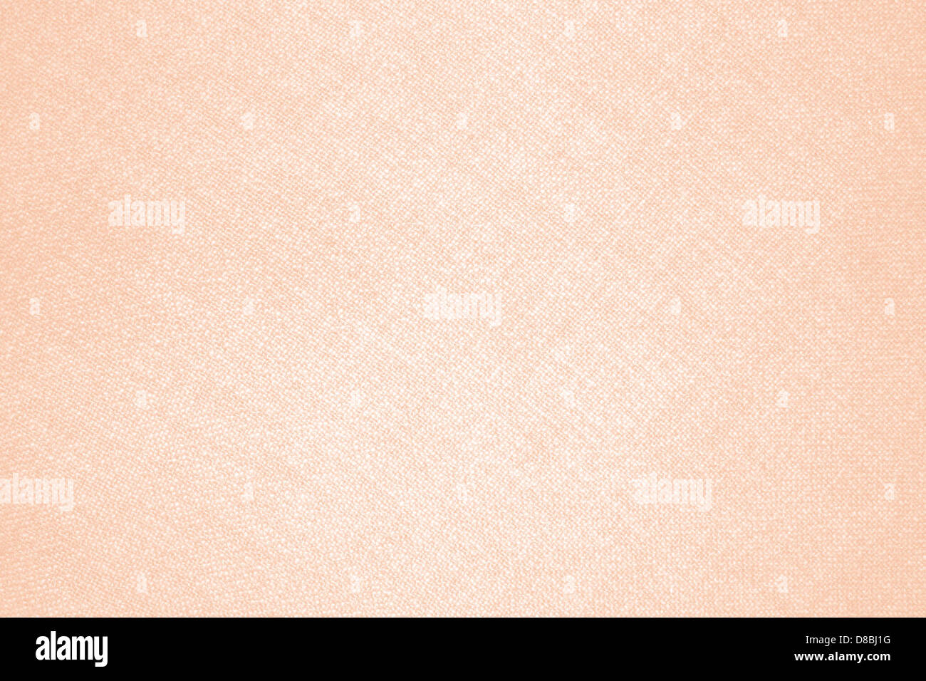 A close-up view of a peach-colored fabric, highlighting its smooth texture and soft appearance ...