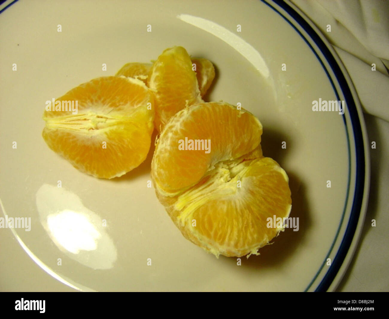 A peeled orange placed on a plate, showcasing its juicy, segmented ...