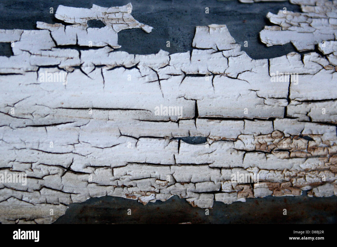 A close-up image showing peeling paint on a surface. The texture ...