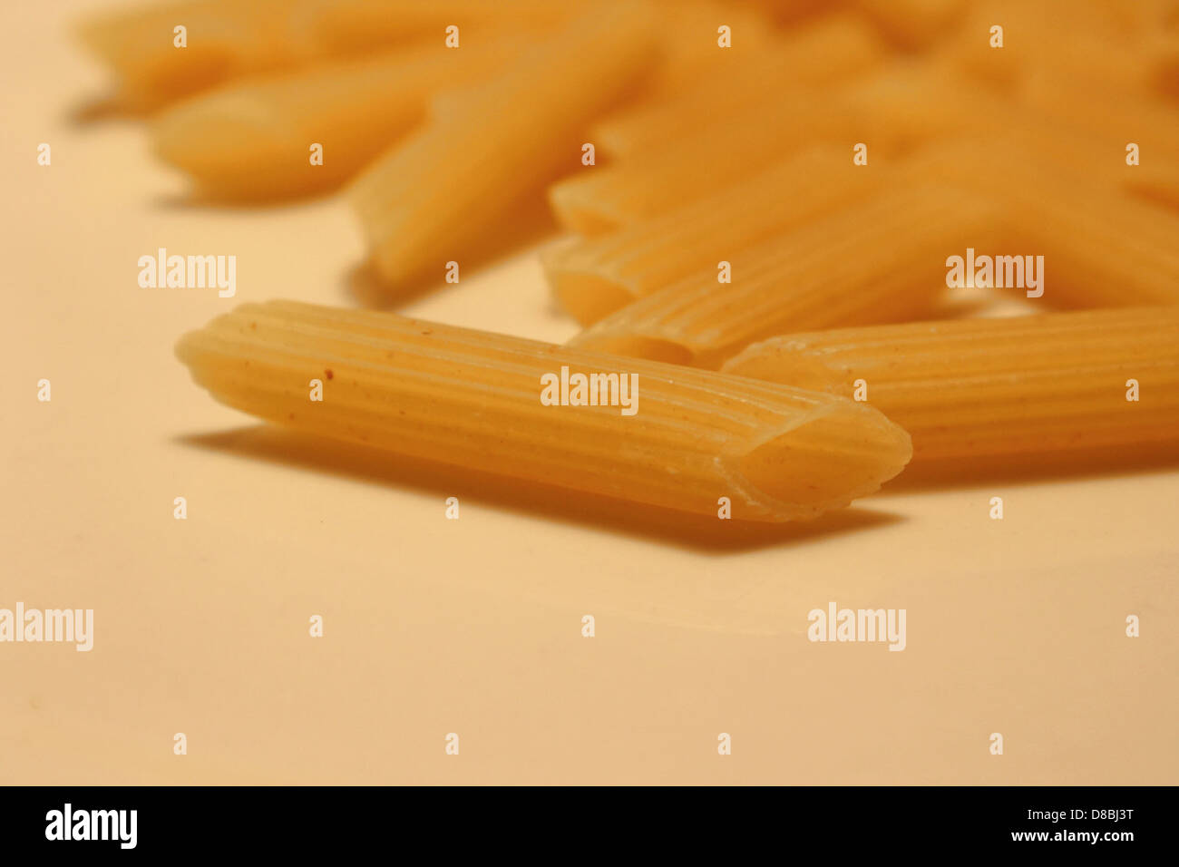 A plate of penne pasta is shown in this image, highlighting the tube ...