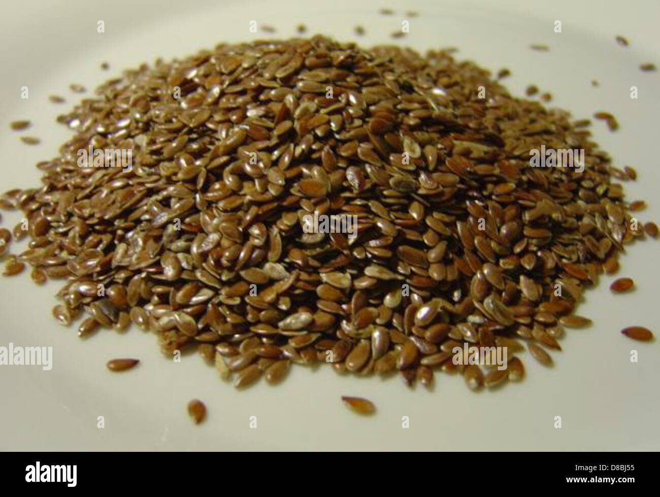 A pile of flax seeds, small and brown, is shown in this image. Flax ...