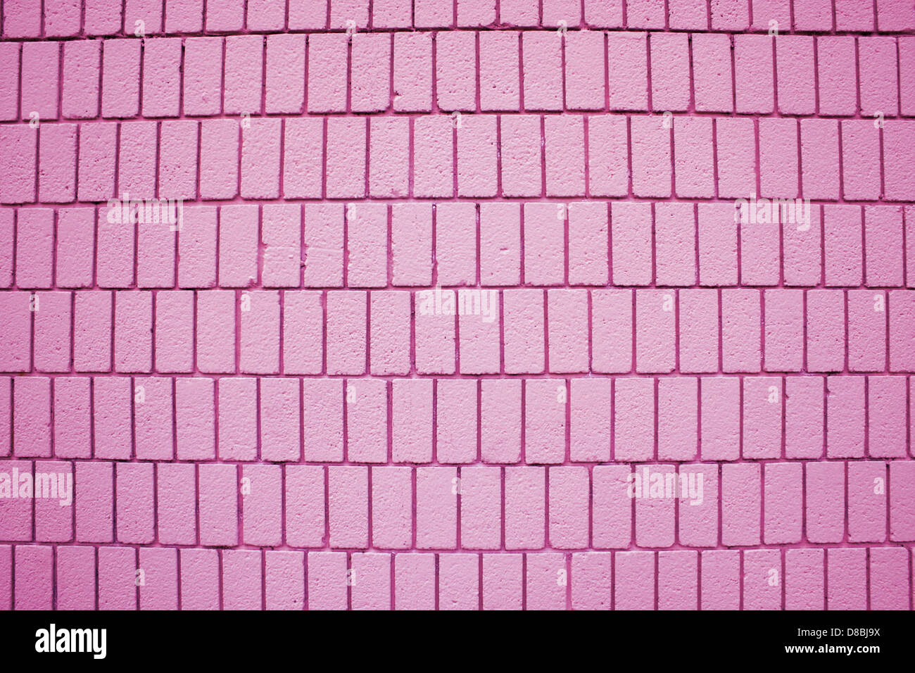 A close-up image of a pink brick wall, where the bricks are arranged ...
