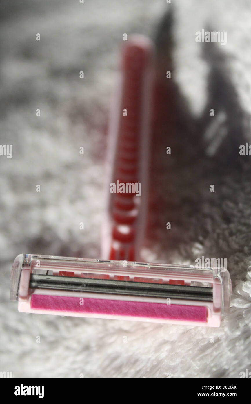 A close-up image of a pink disposable razor, designed for personal ...
