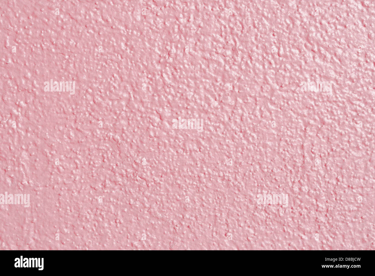 A close-up image of a pink-painted wall texture, showing the smooth or ...