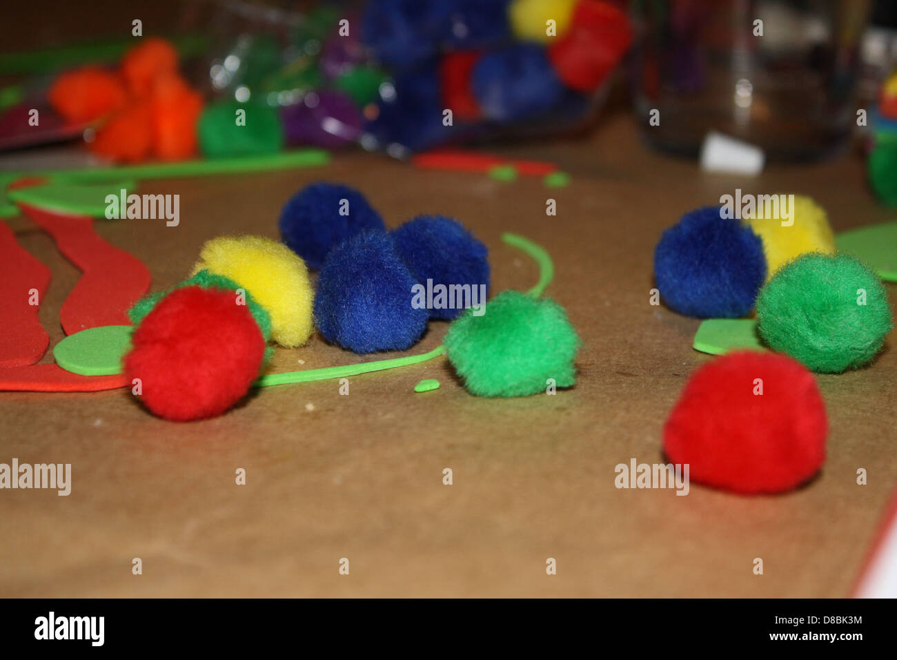Colorful pom poms are shown, often used in various craft projects ...