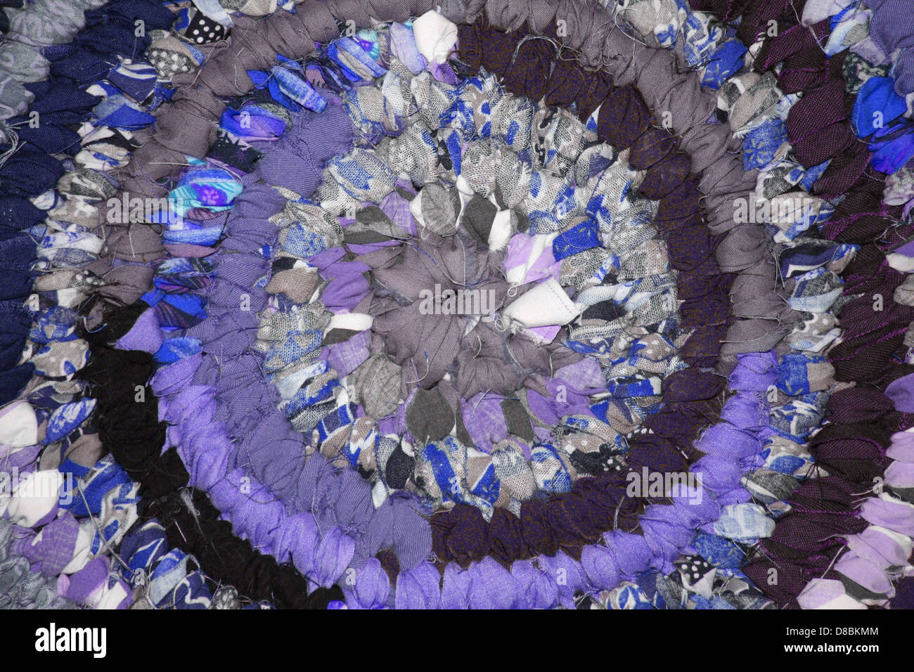 A close-up shot of a purple rag rug, showcasing its intricate woven ...