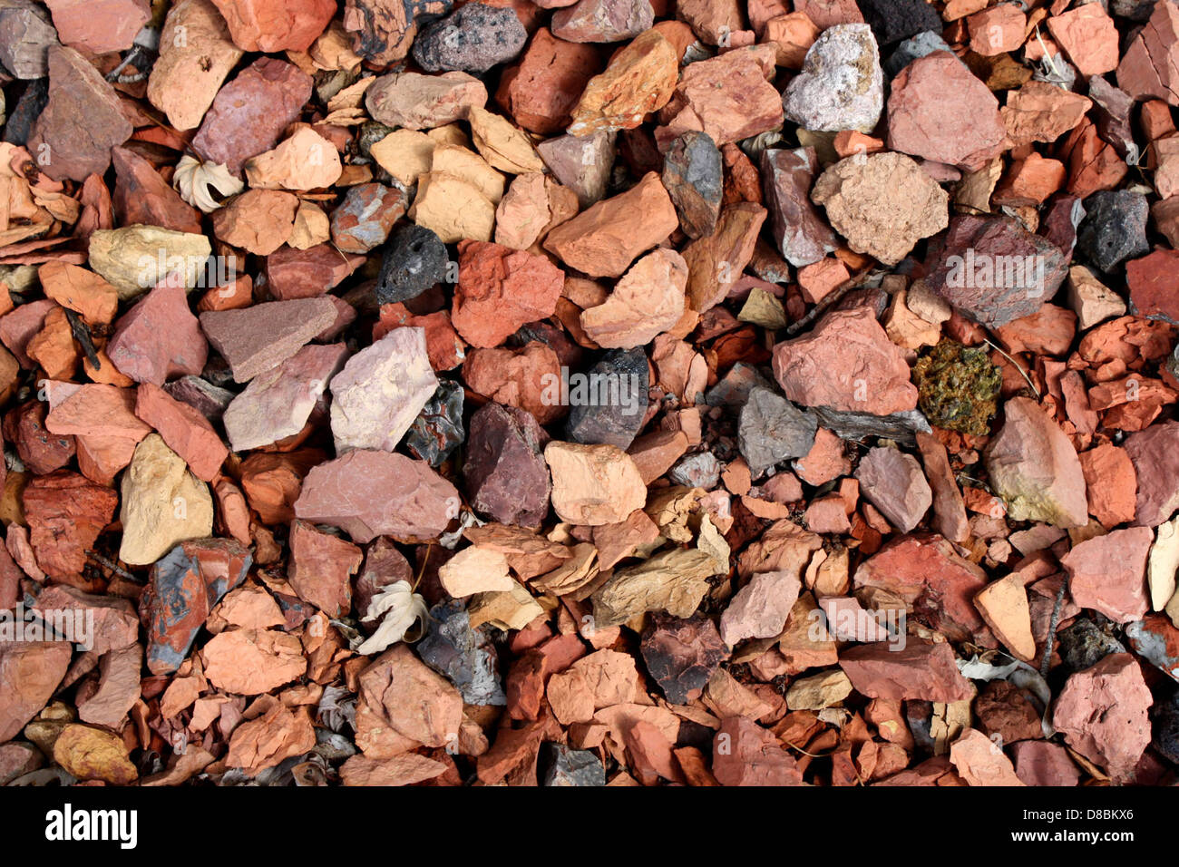 A close-up of red and black gravel rocks, showing the texture and color ...