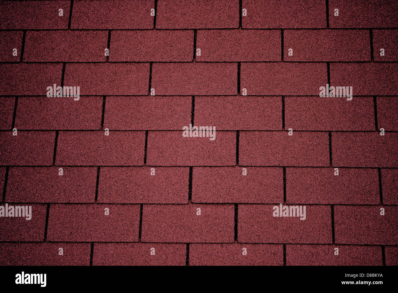A close-up view of red asphalt roof shingles, commonly used in ...