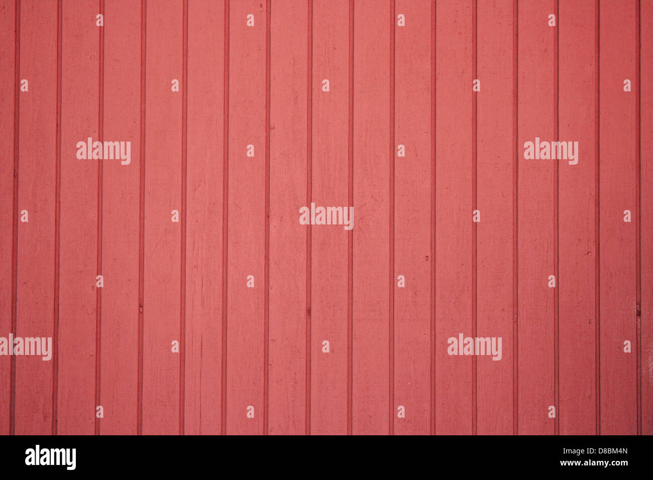 A close-up of red-painted vertical siding, commonly used in building ...