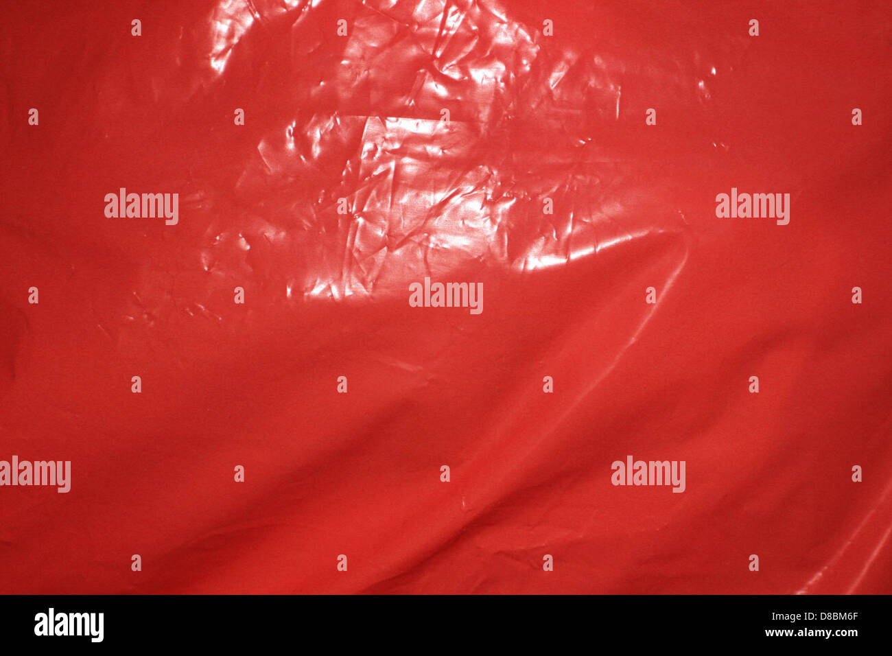 A close-up shot of red plastic material, showing its smooth, glossy ...