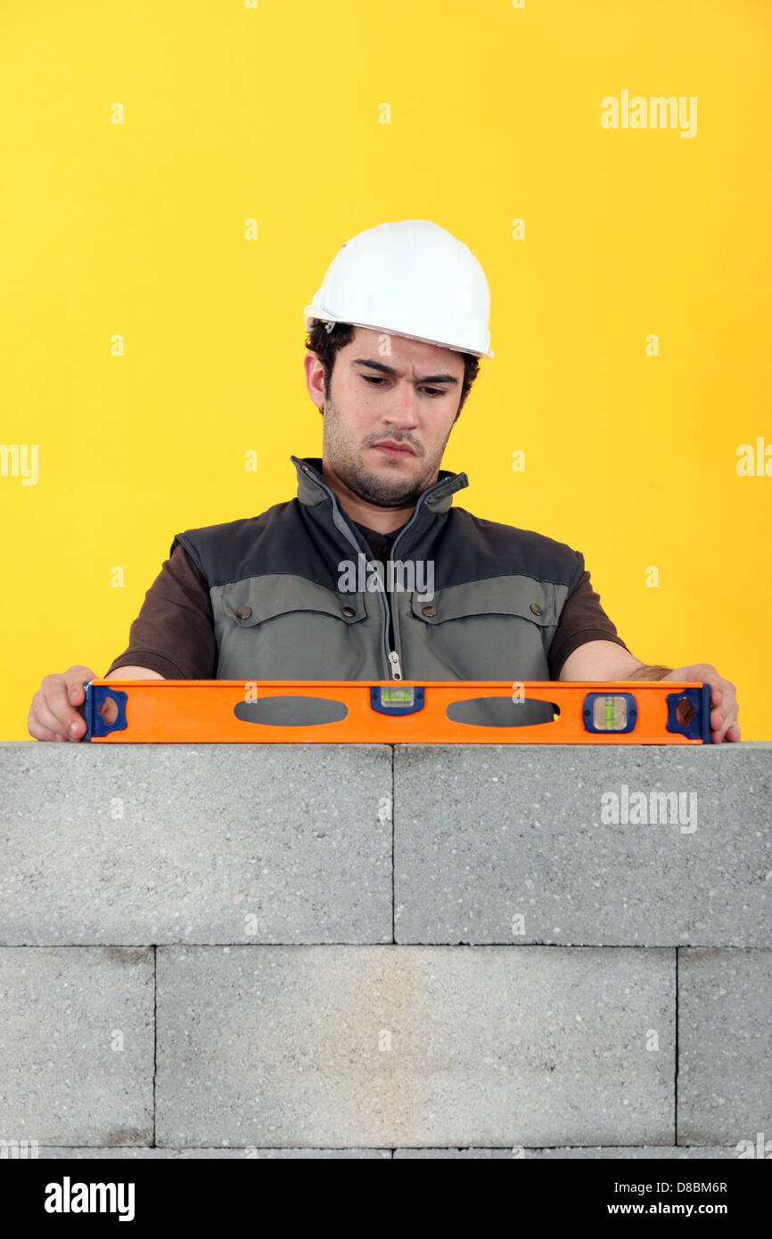 Bricklayer with a spirit level Stock Photo - Alamy