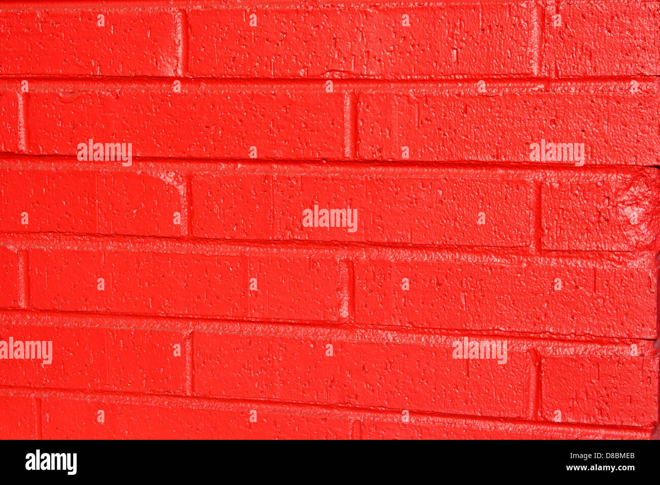 A close-up of a red-painted brick wall, showcasing the texture and ...