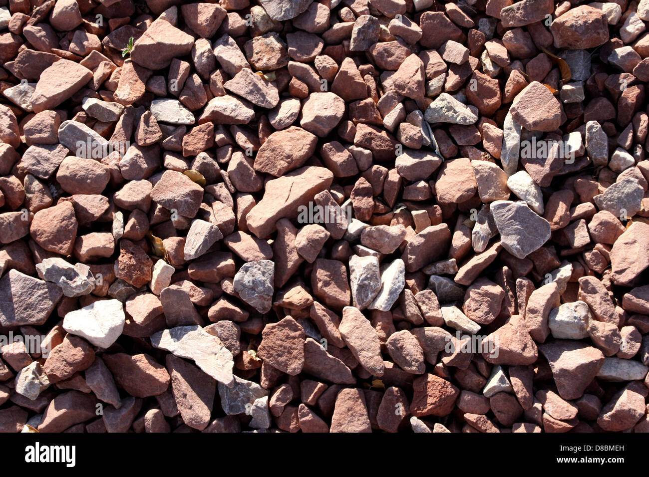 The image showcases the texture of red rock gravel, with fine details ...