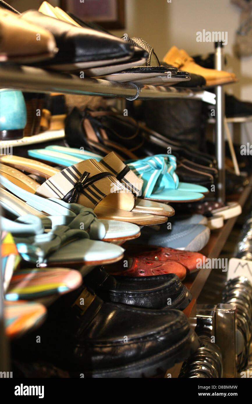 A display of rows of shoes arranged neatly at a thrift store. The shoes ...