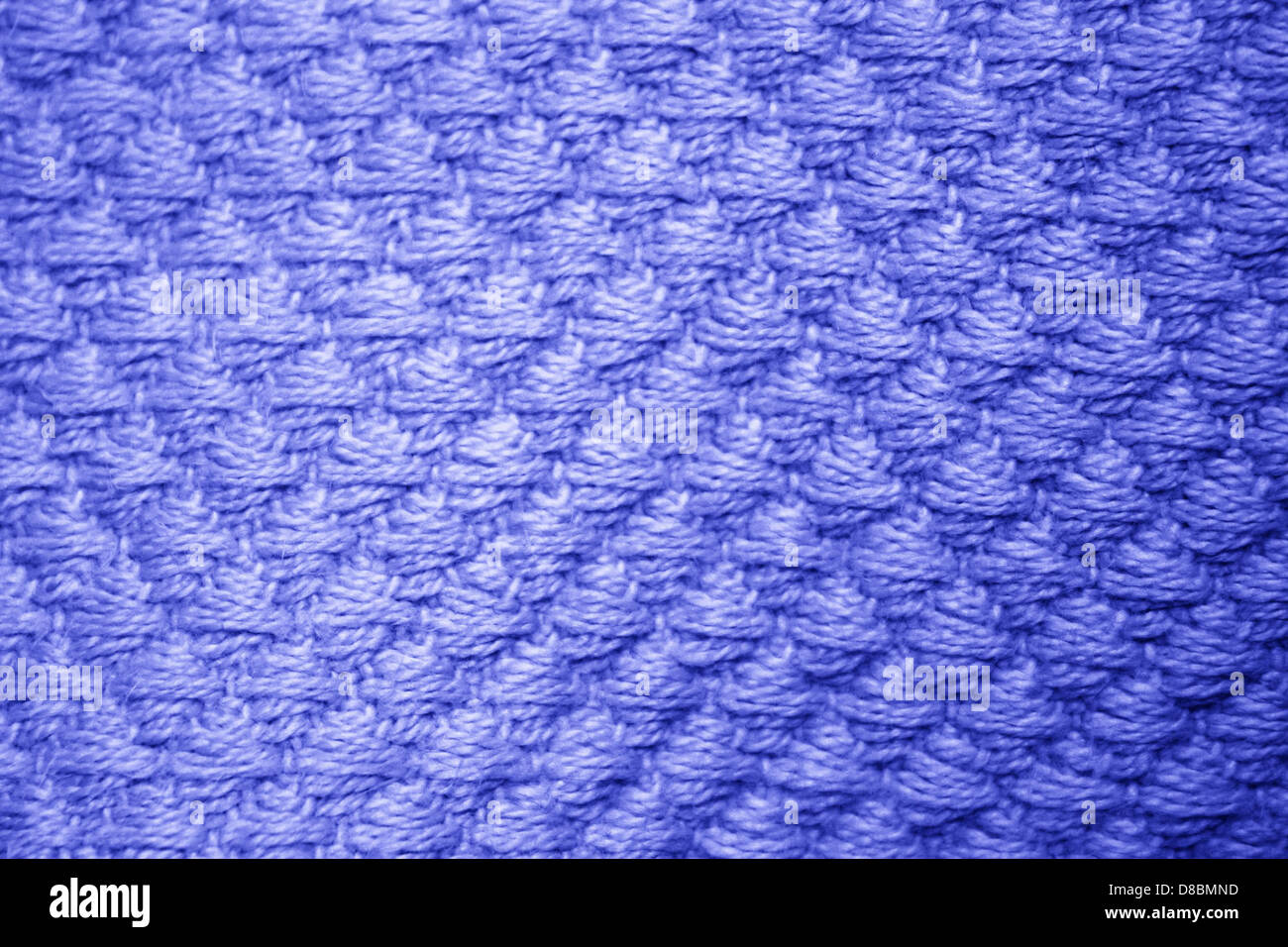 A close-up view of a royal blue blanket featuring a diamond pattern ...