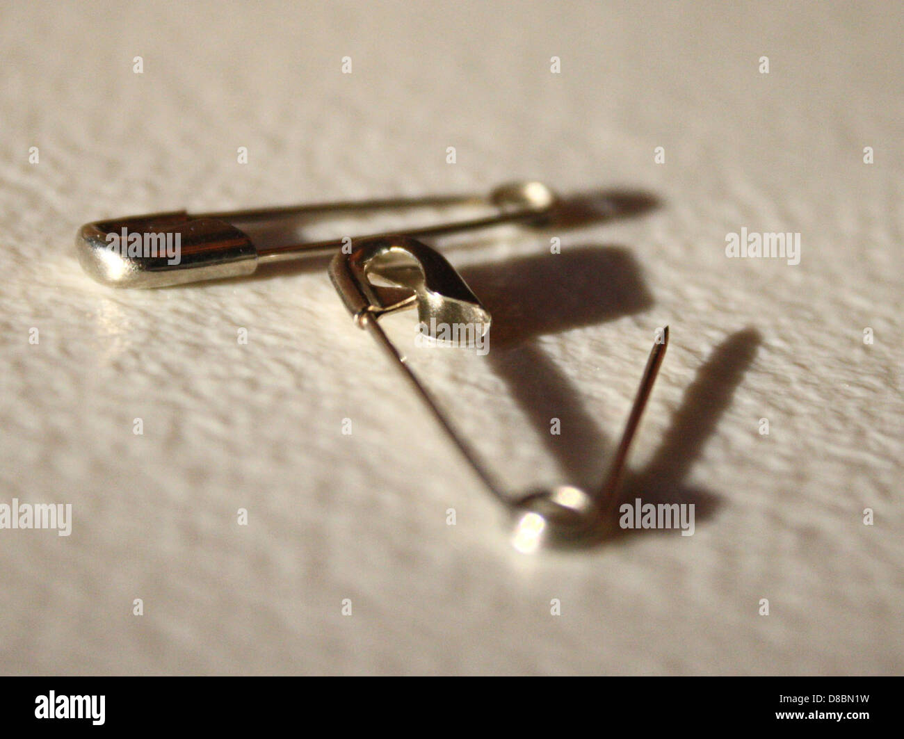 A close-up image of safety pins, highlighting their metal finish and ...