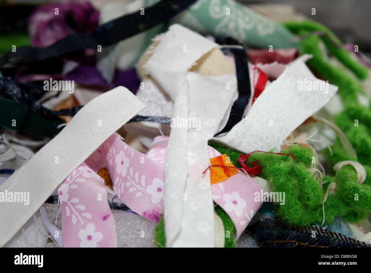 Scattered scraps of cloth in various colors and textures are shown ...