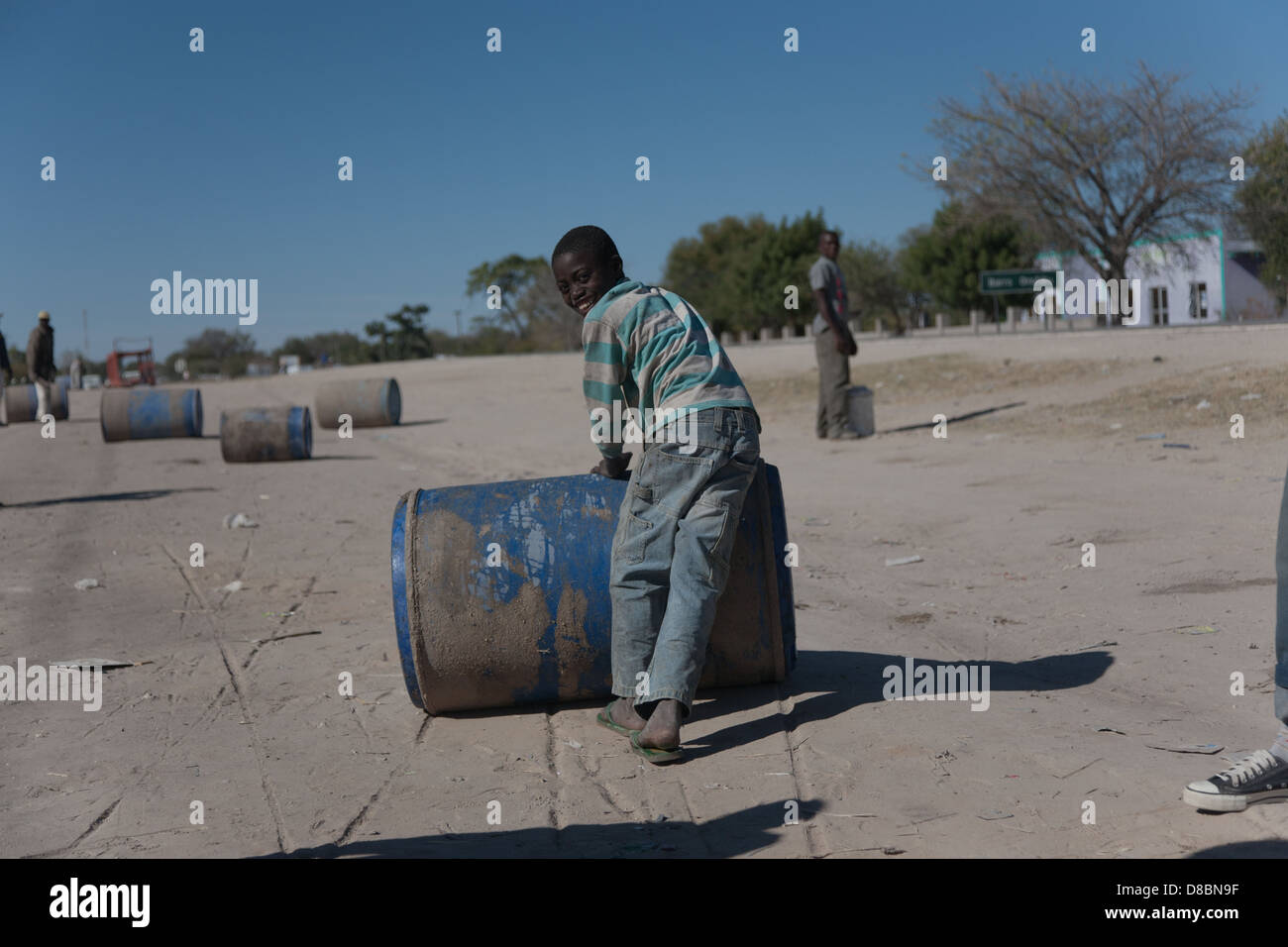 African man rolling barrel of water Stock Photo - Alamy
