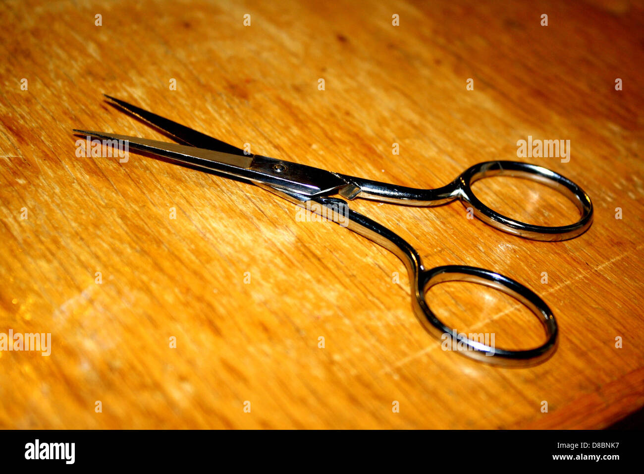 A pair of silver scissors, with sharp, clean blades, placed on a flat ...