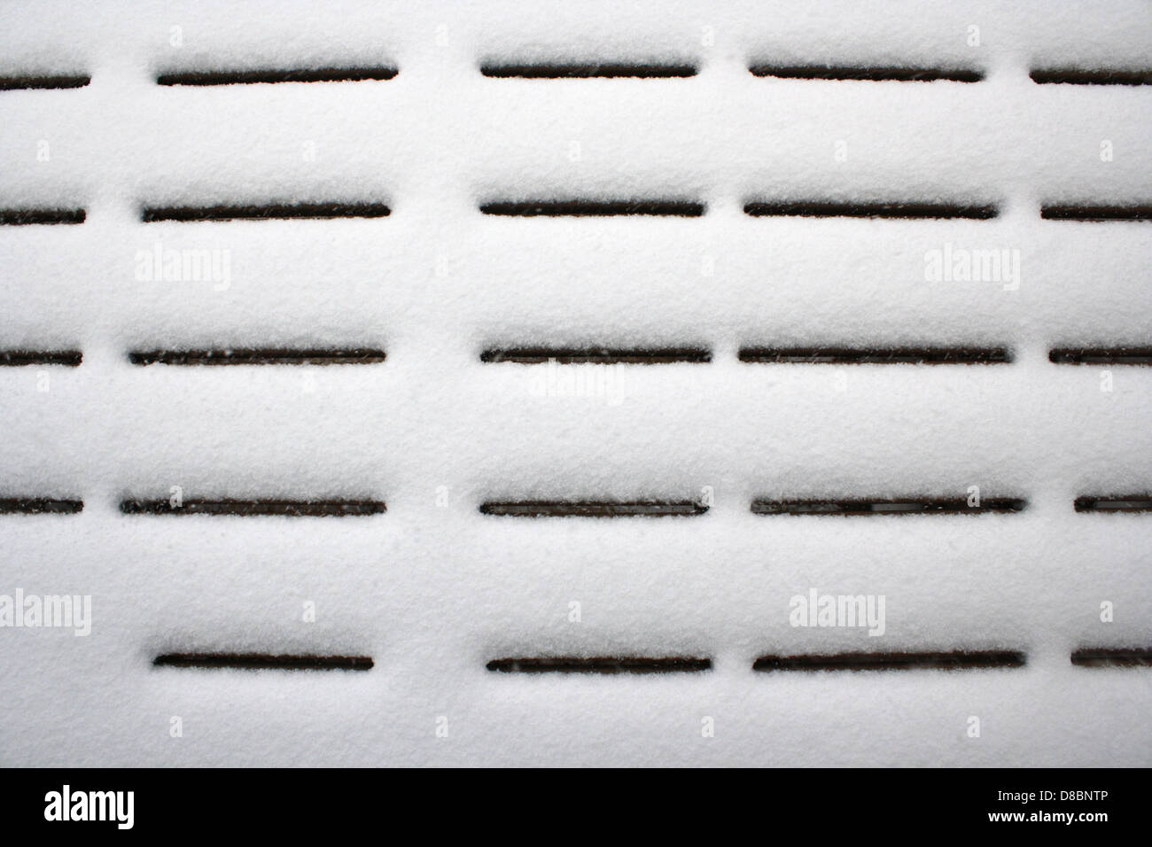 A close-up view of snow-covered deck boards, with the texture of the ...