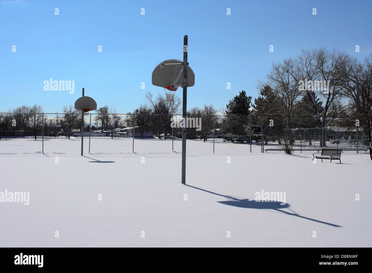 An outdoor basketball court covered in a blanket of snow. The image ...