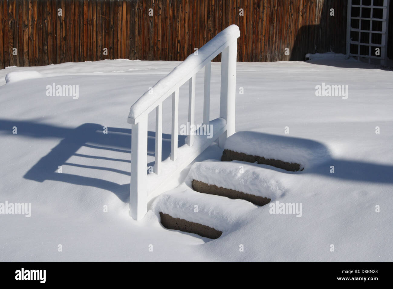 Steps and a railing covered in fresh snow, creating a wintery scene ...