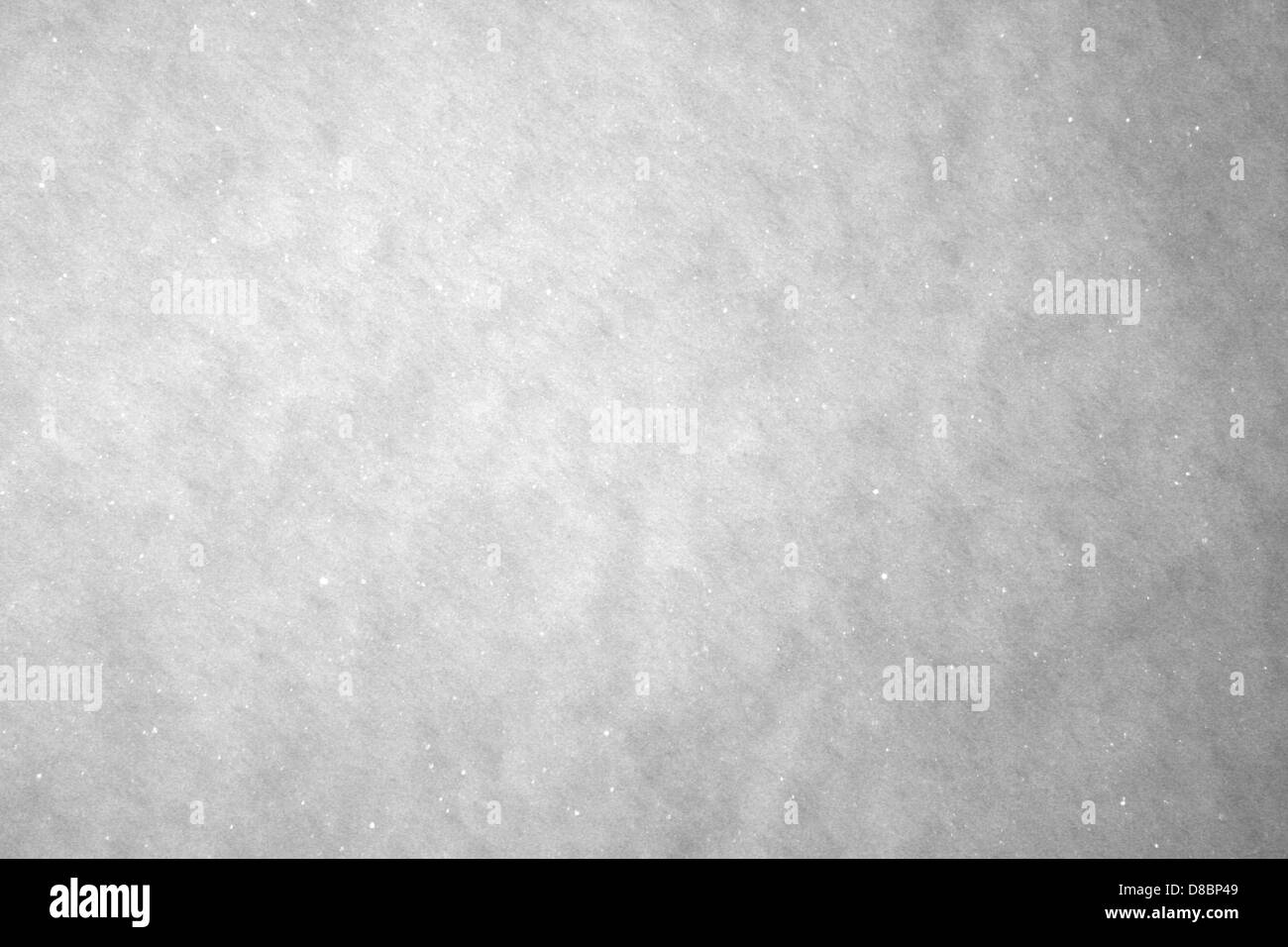 The image shows a close-up of sparkling snow with a textured surface ...