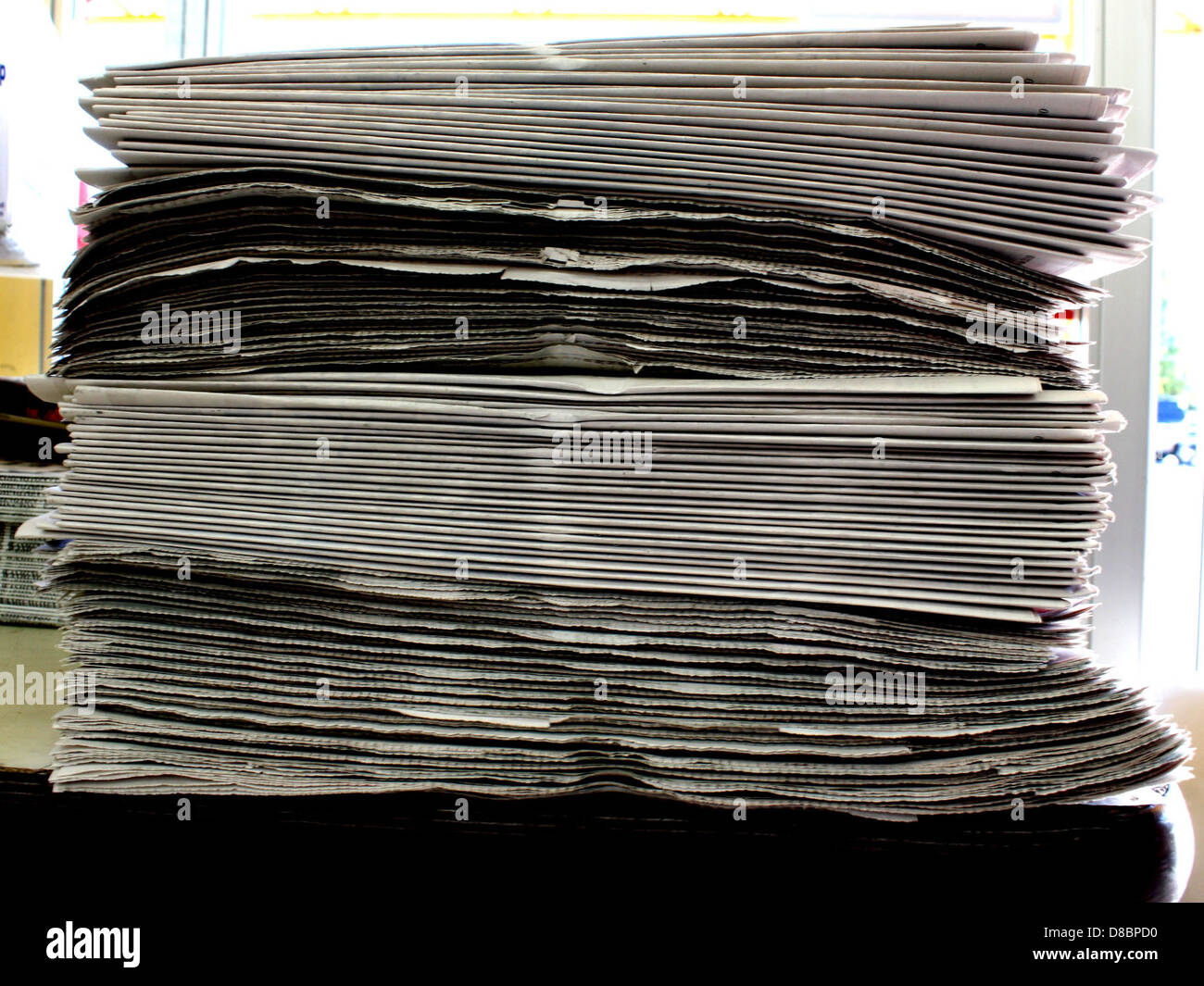 A neat stack of newspapers, showcasing the printed media format, with ...