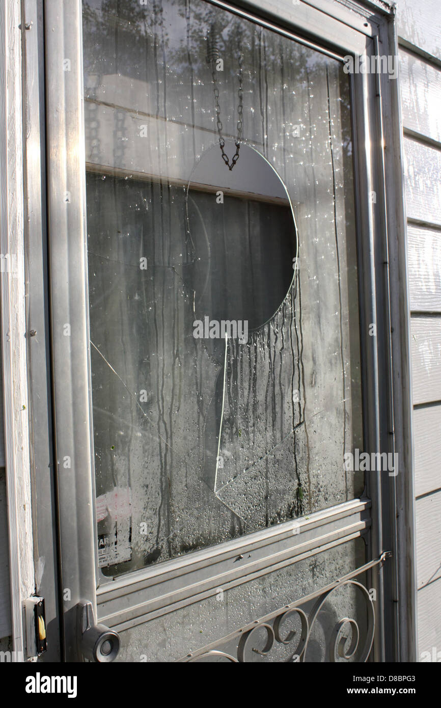 A storm door with broken glass, showing the damage caused by weather or ...