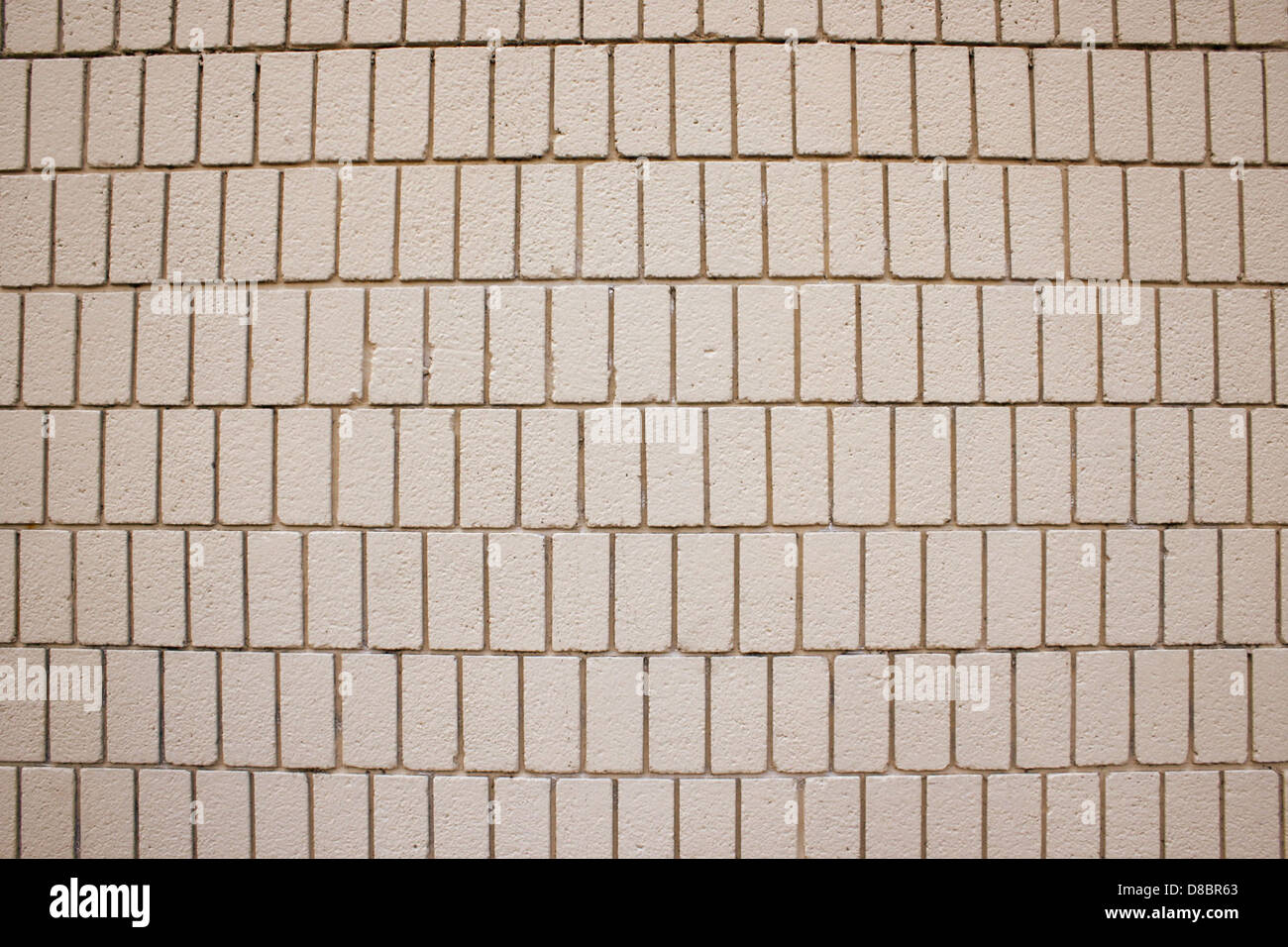 A tan brick wall with vertical brick arrangements. The smooth texture ...