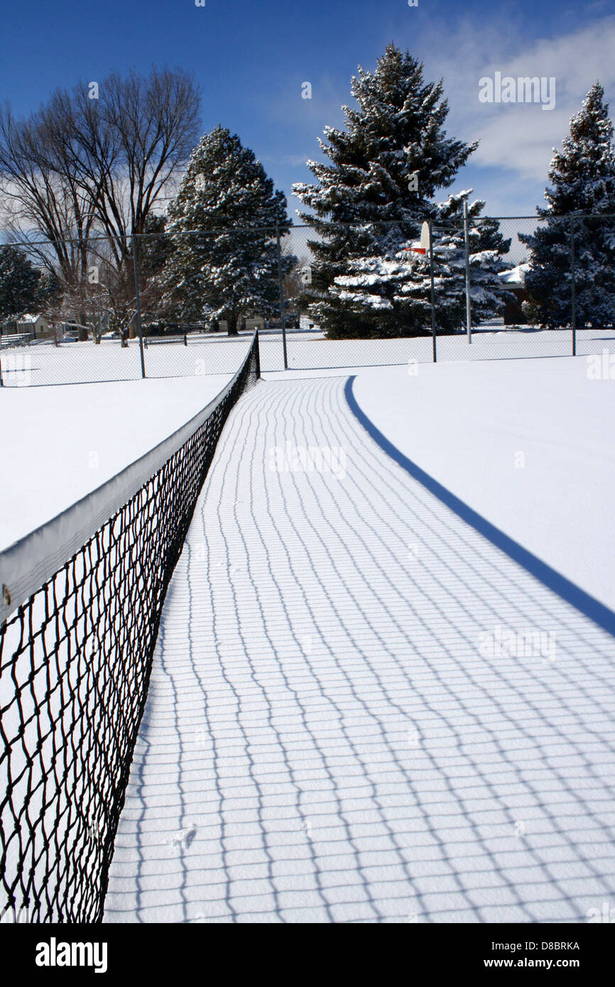 A tennis court net is completely covered by a thick layer of snow ...